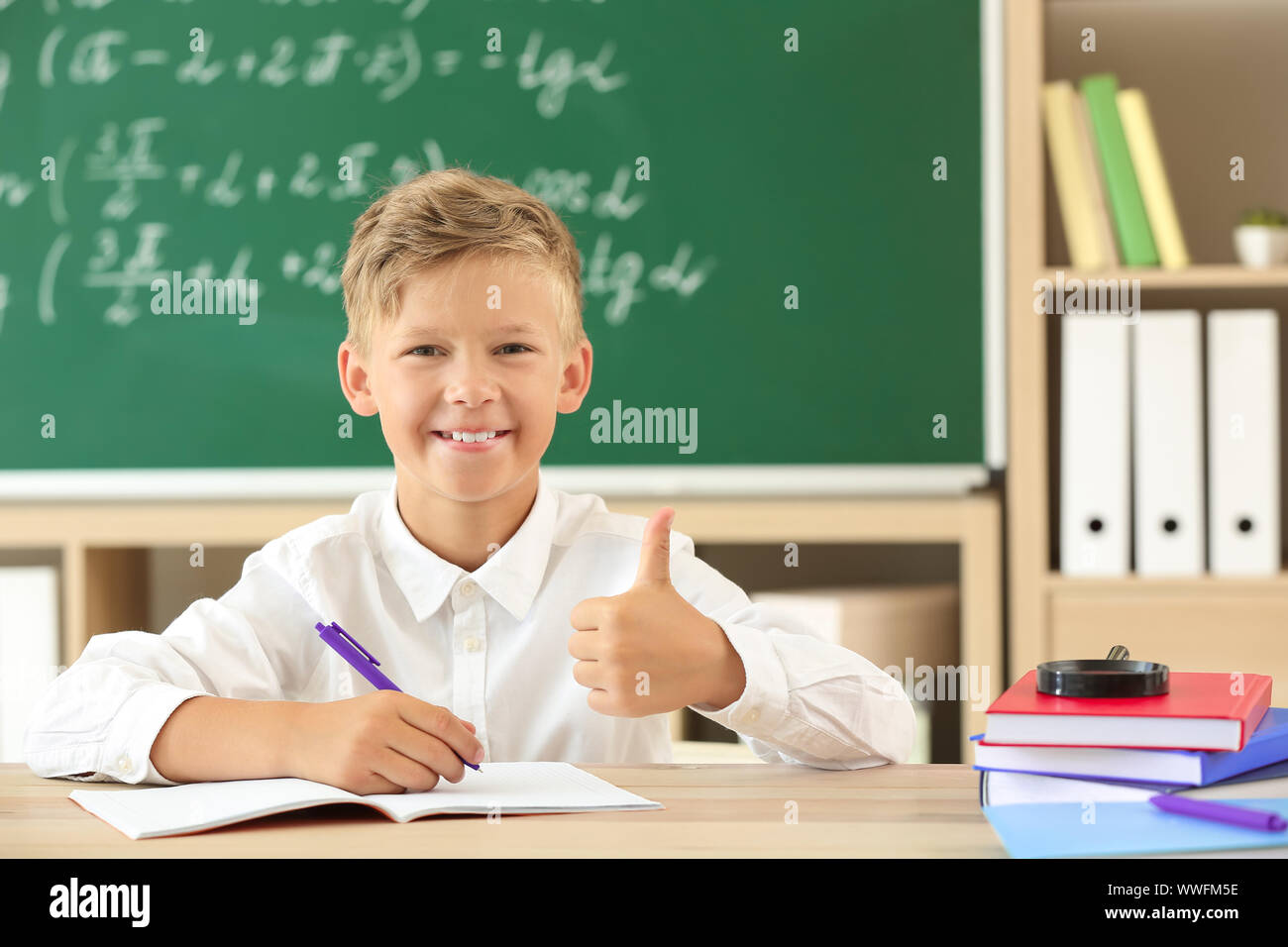 Little boy doing homework in classroom Stock Photo - Alamy