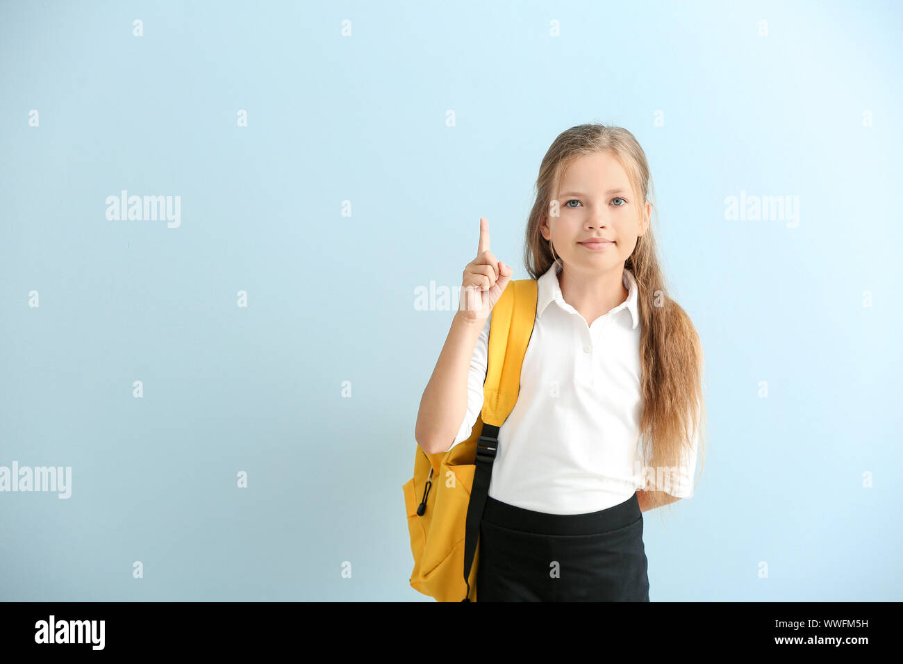 Little schoolgirl with raised index finger on color background Stock ...