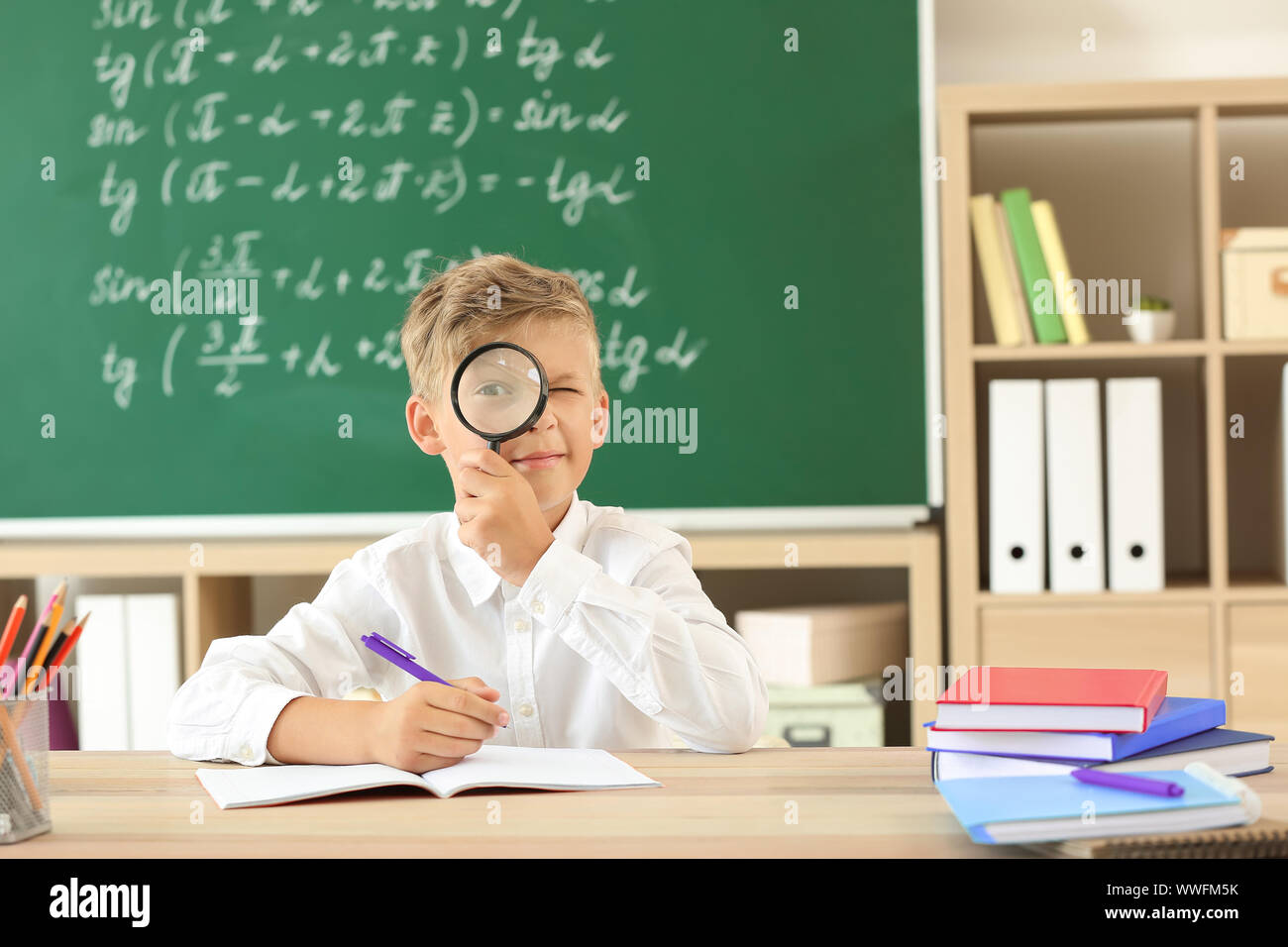 Little boy doing homework in classroom Stock Photo - Alamy
