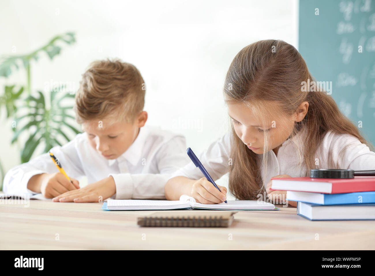 Little pupils doing lessons in classroom Stock Photo - Alamy
