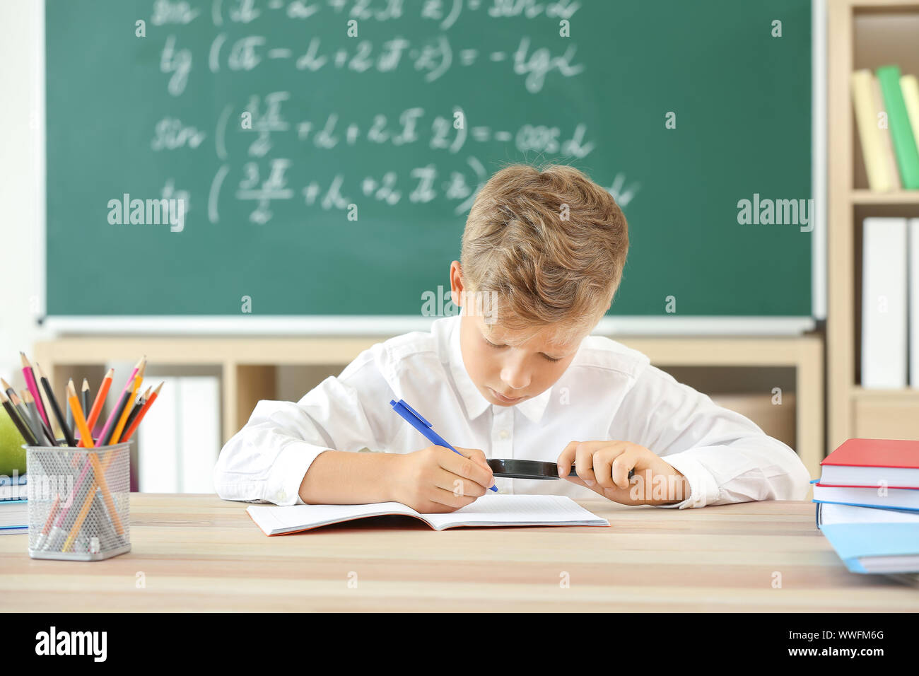 Little boy doing homework in classroom Stock Photo - Alamy