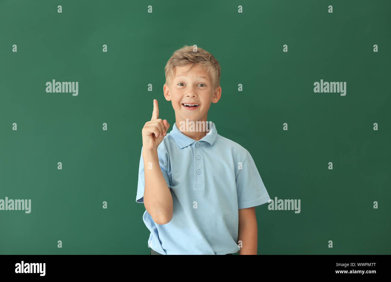 Little schoolboy with raised index finger on color background Stock ...