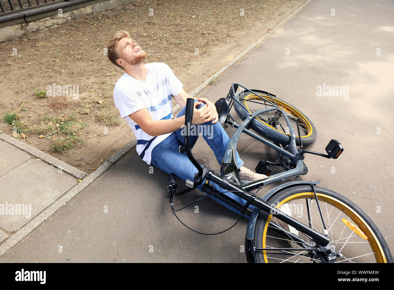 Young man fallen off his bicycle outdoors Stock Photo - Alamy