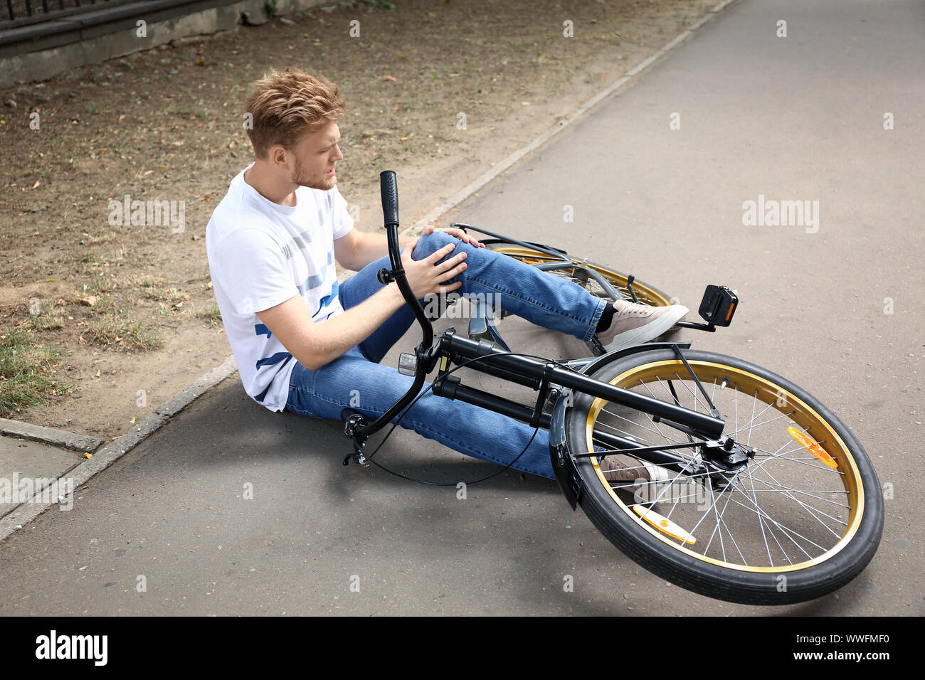 Young man fallen off his bicycle outdoors Stock Photo - Alamy