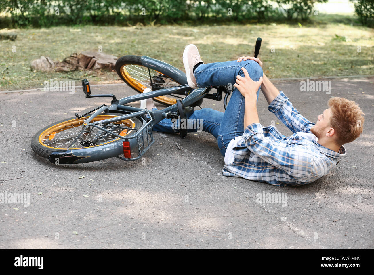 Young man fallen off his bicycle outdoors Stock Photo - Alamy