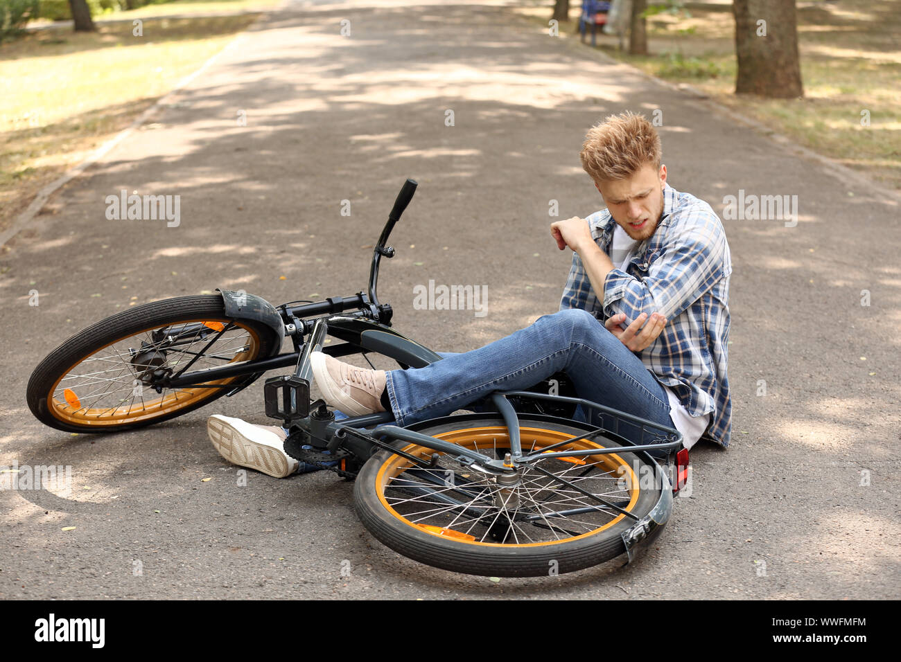 Young man fallen off his bicycle outdoors Stock Photo - Alamy