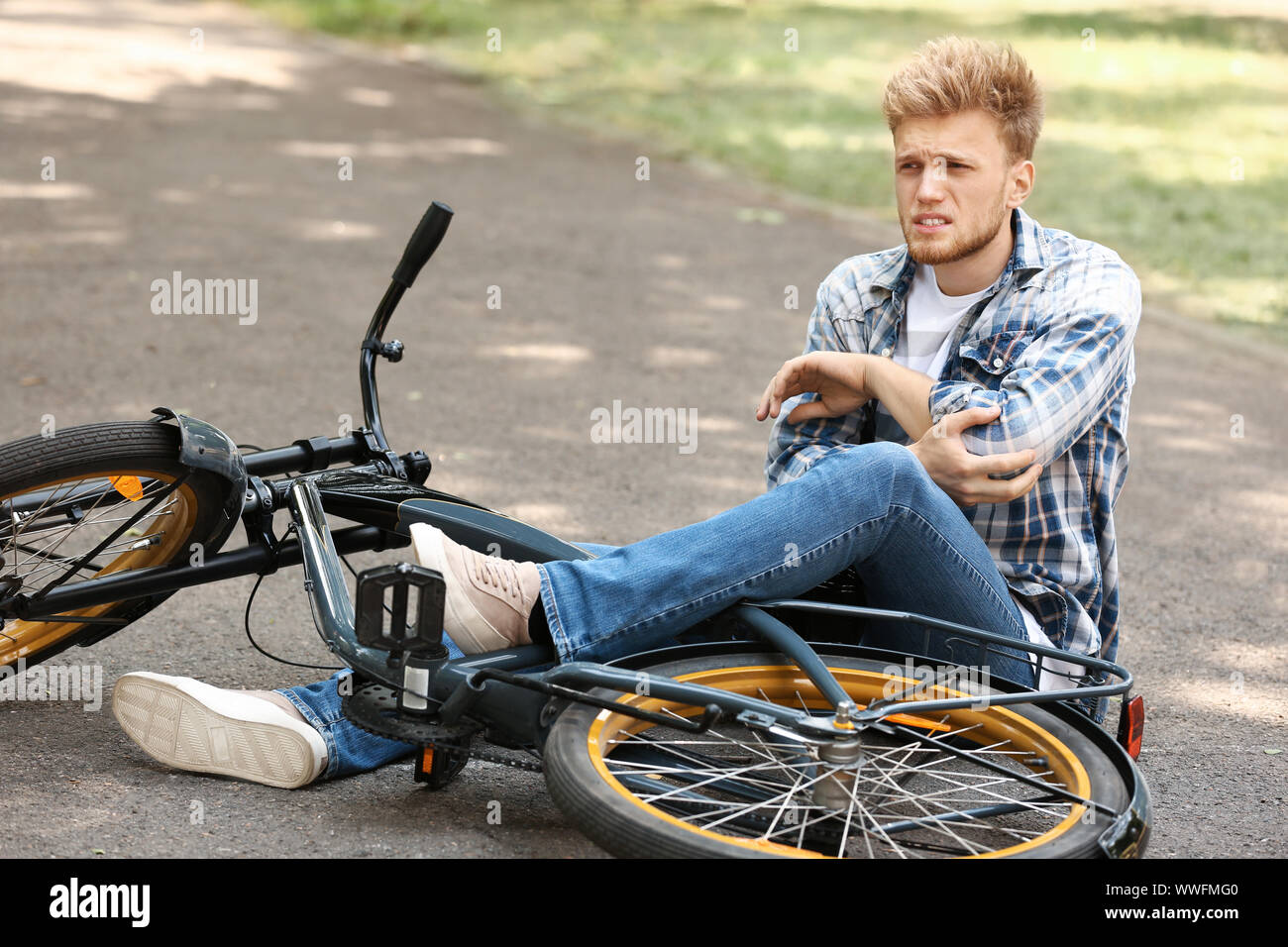 Young man fallen off his bicycle outdoors Stock Photo - Alamy