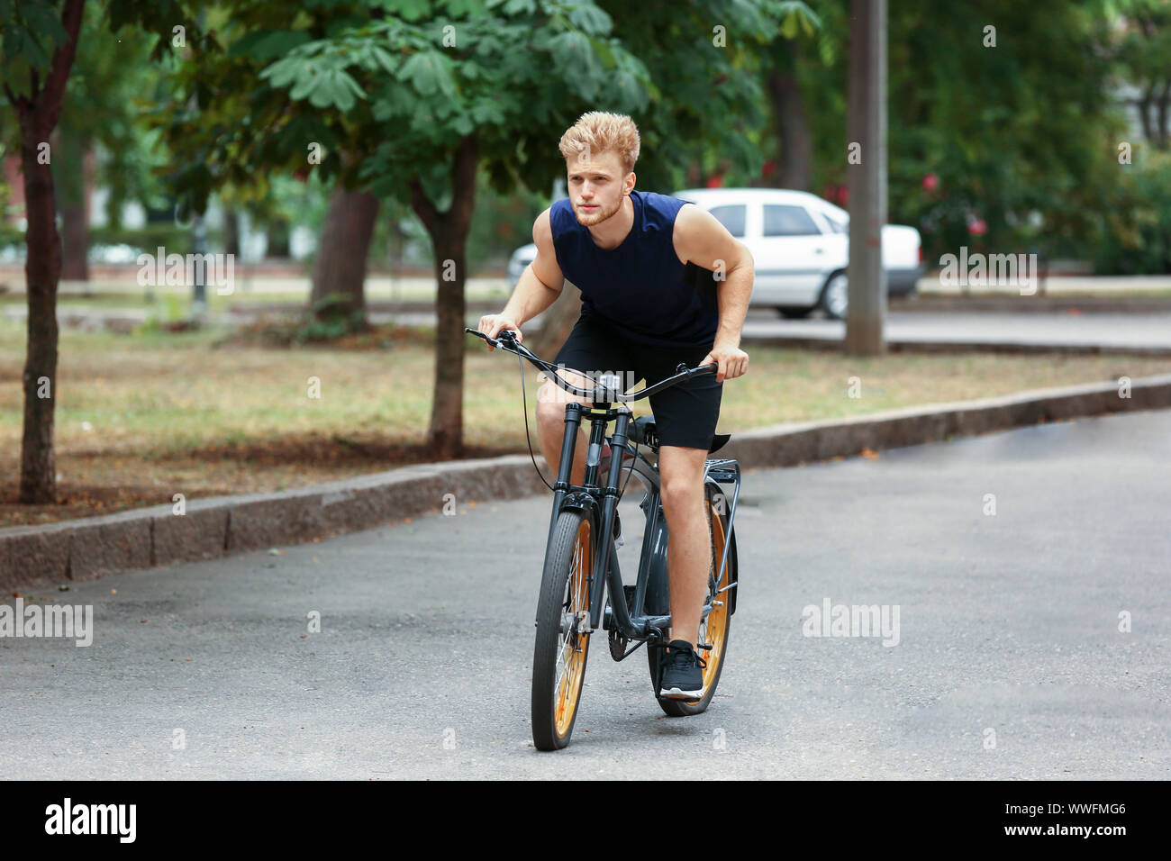 Sporty young man riding bicycle outdoors Stock Photo - Alamy