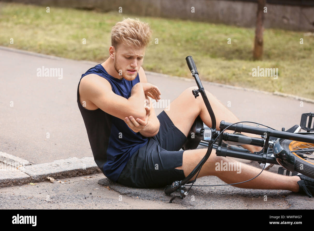 Sporty young man fallen off his bicycle outdoors Stock Photo - Alamy