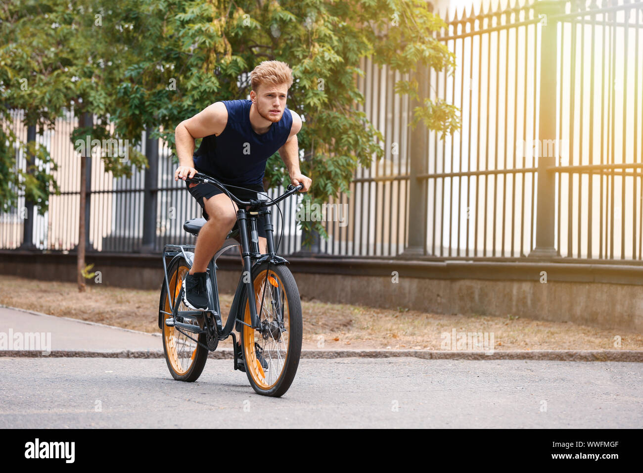Sporty young man riding bicycle outdoors Stock Photo - Alamy