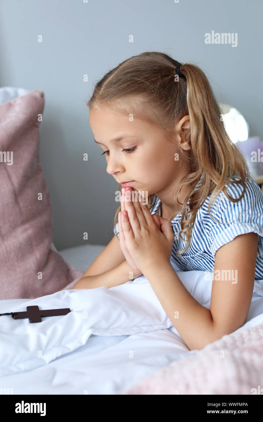 Cute little girl praying in bedroom Stock Photo - Alamy