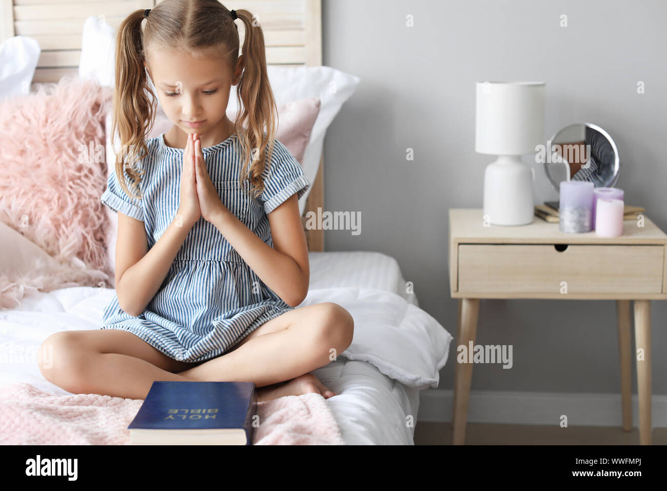 Cute little girl praying in bedroom Stock Photo - Alamy