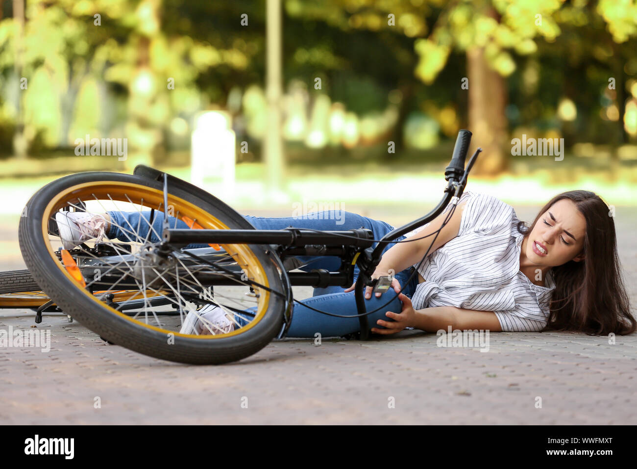 Young woman fallen off her bicycle outdoors Stock Photo - Alamy
