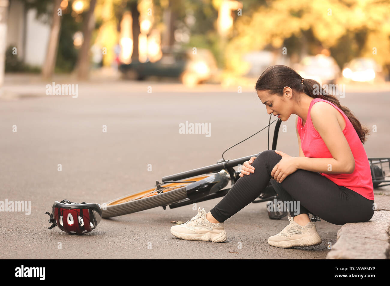 Sporty young woman fallen off her bicycle outdoors Stock Photo - Alamy