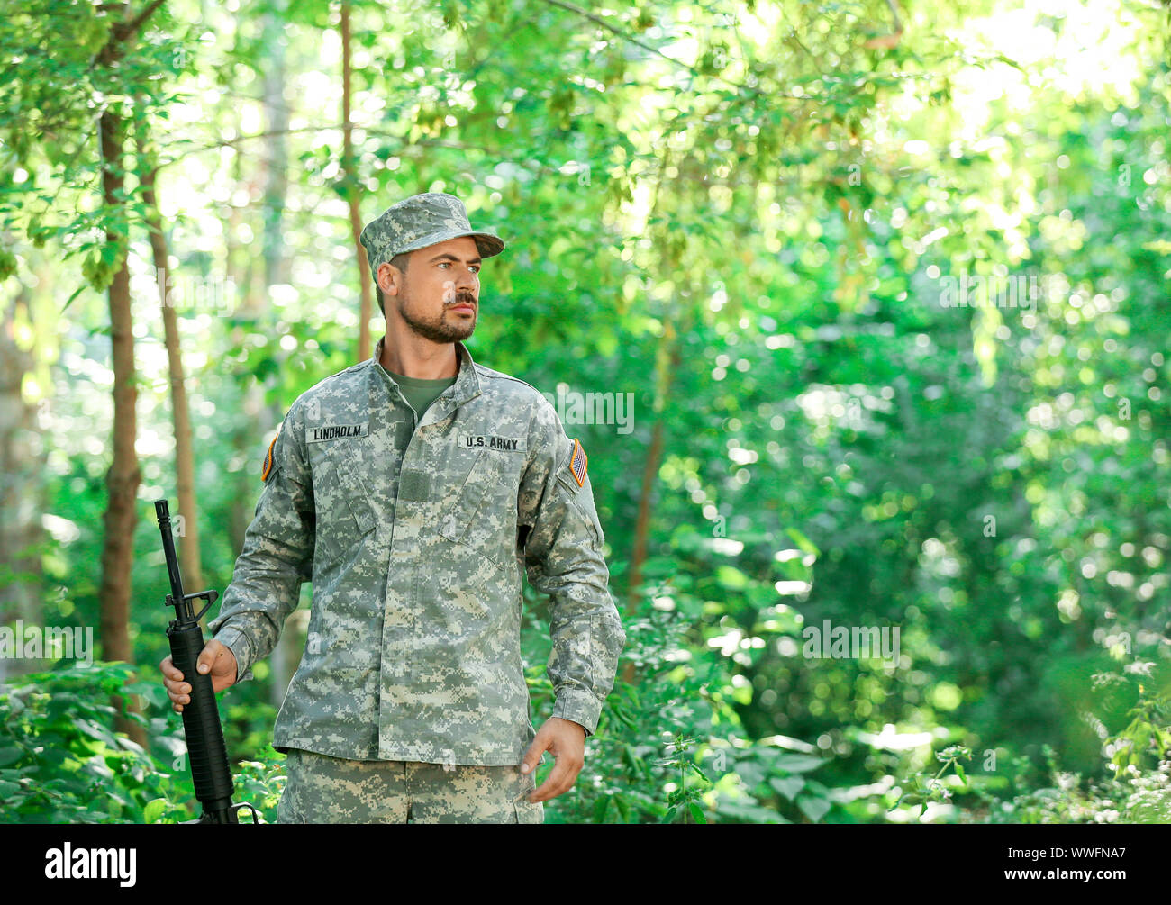 Soldier with assault rifle in forest Stock Photo - Alamy