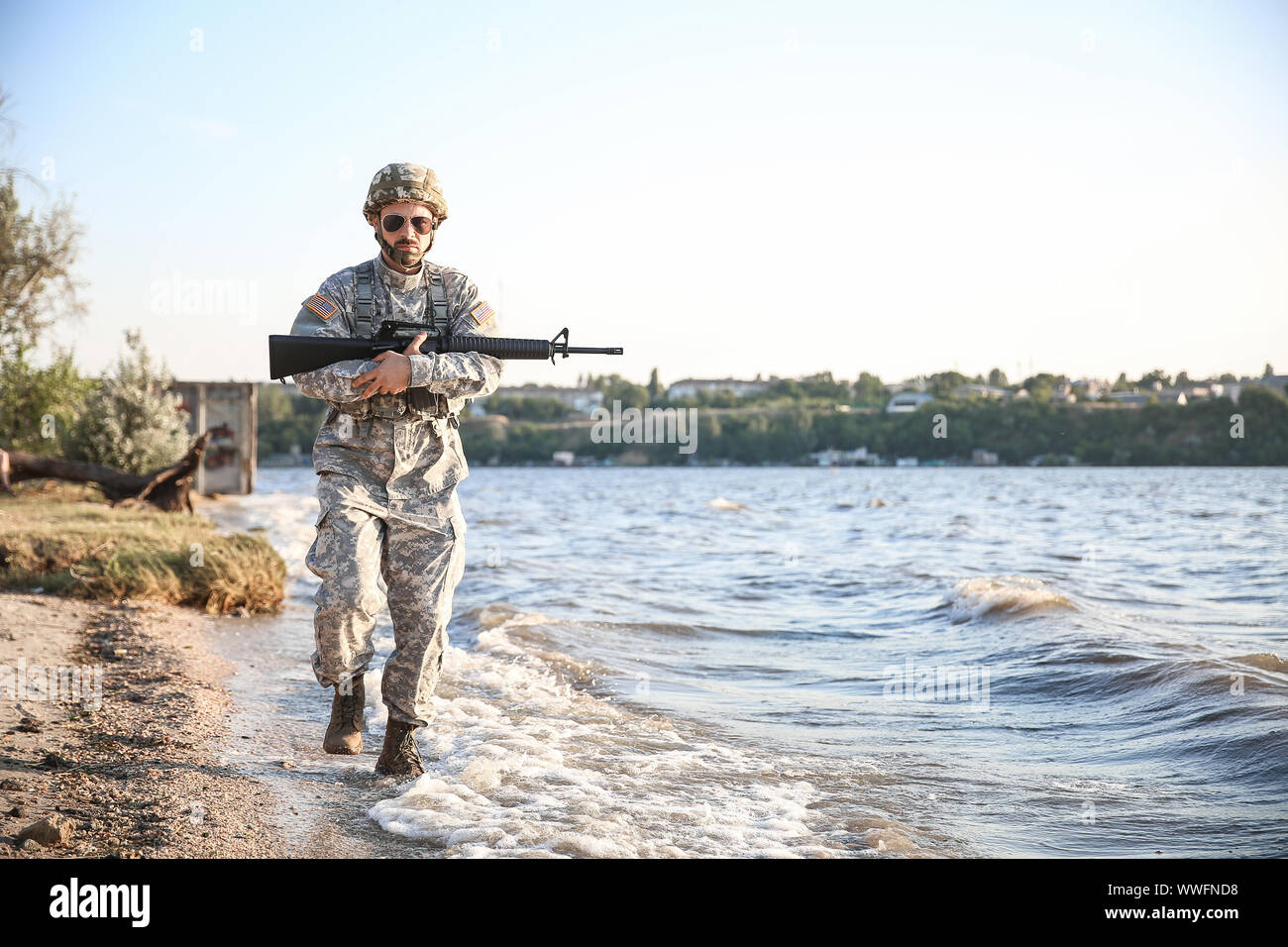 Going soldier in camouflage with assault rifle near river Stock Photo ...