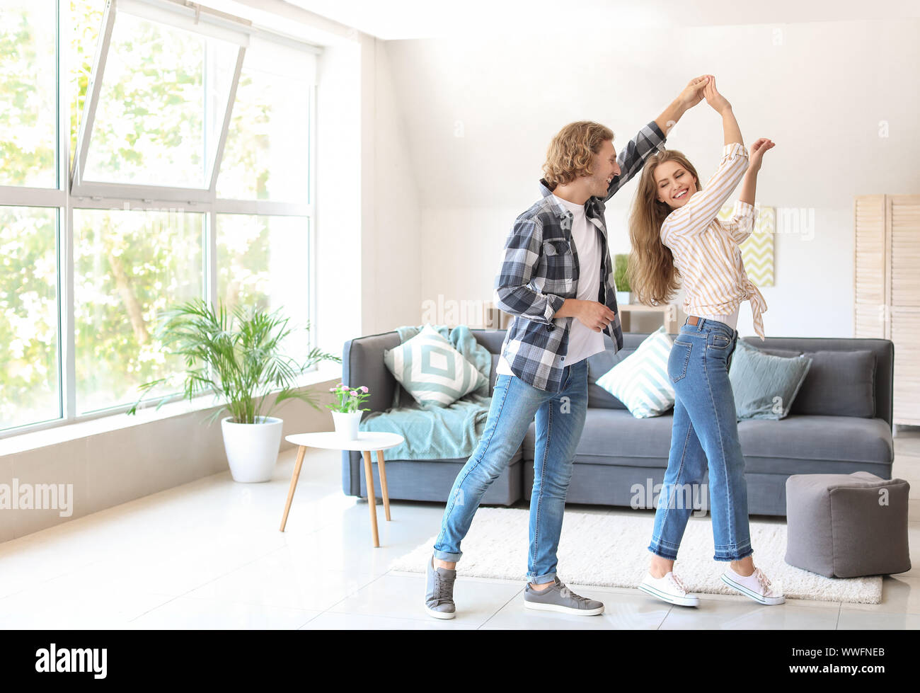 Happy young couple dancing at home Stock Photo - Alamy