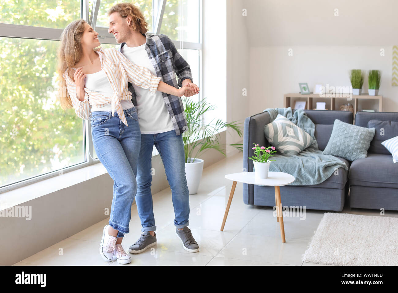 Happy young couple dancing at home Stock Photo - Alamy