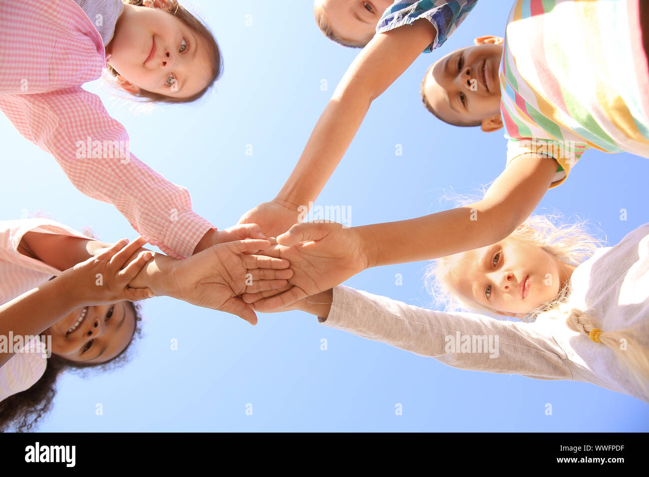 Cute little children putting hands together outdoors, bottom view Stock ...