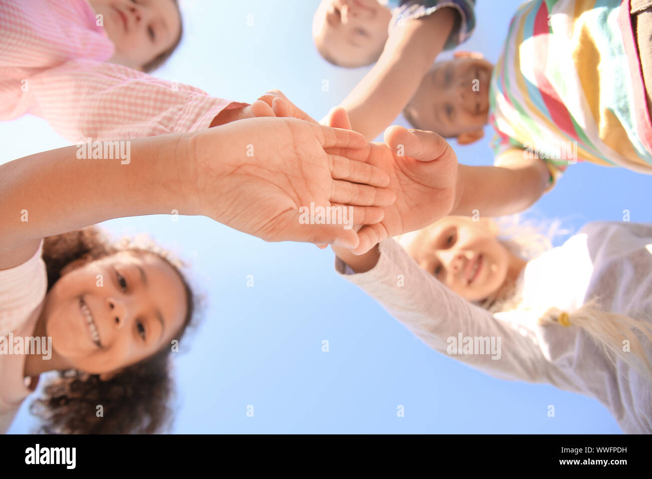 Cute little children putting hands together outdoors, bottom view Stock ...