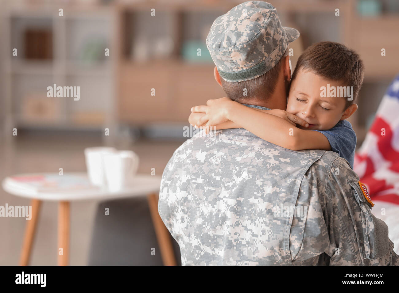 Happy military man hugging his son at home Stock Photo - Alamy