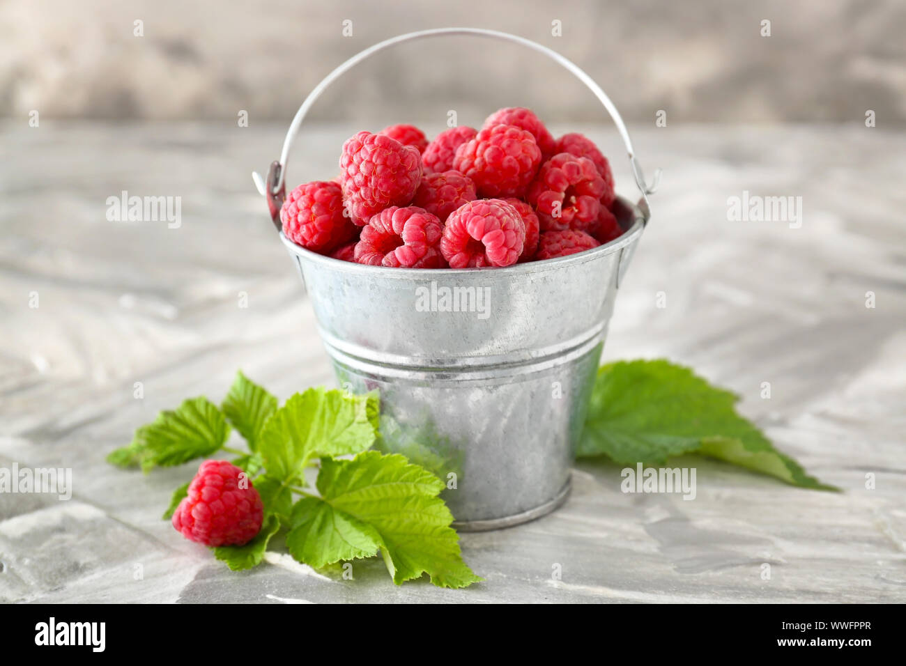 Bucket with sweet ripe raspberries on grunge background Stock Photo - Alamy