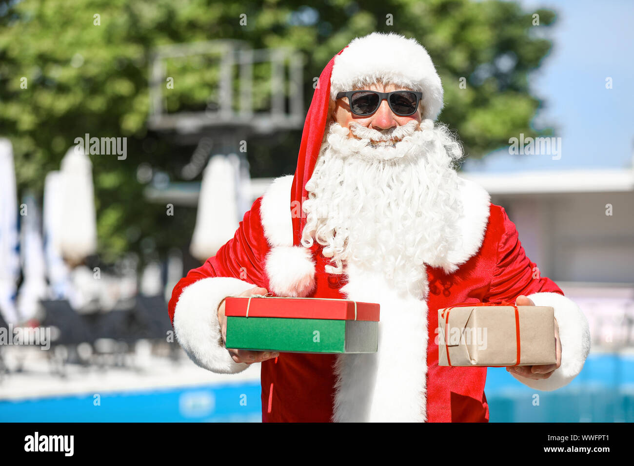 Cool Santa Claus with gifts at resort Stock Photo - Alamy