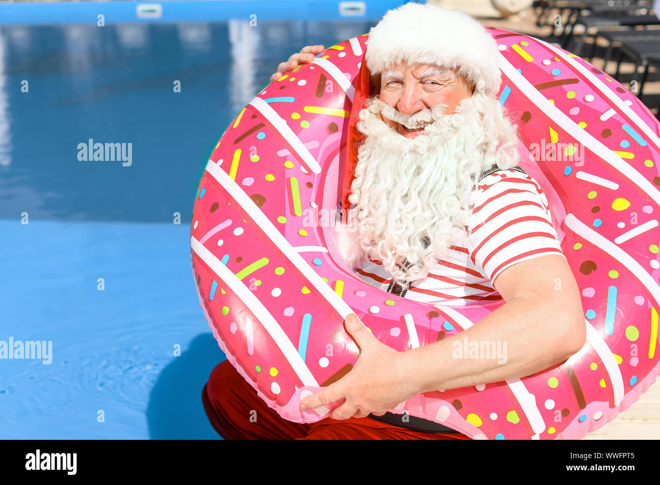 Santa Claus with inflatable ring near swimming pool at resort Stock ...