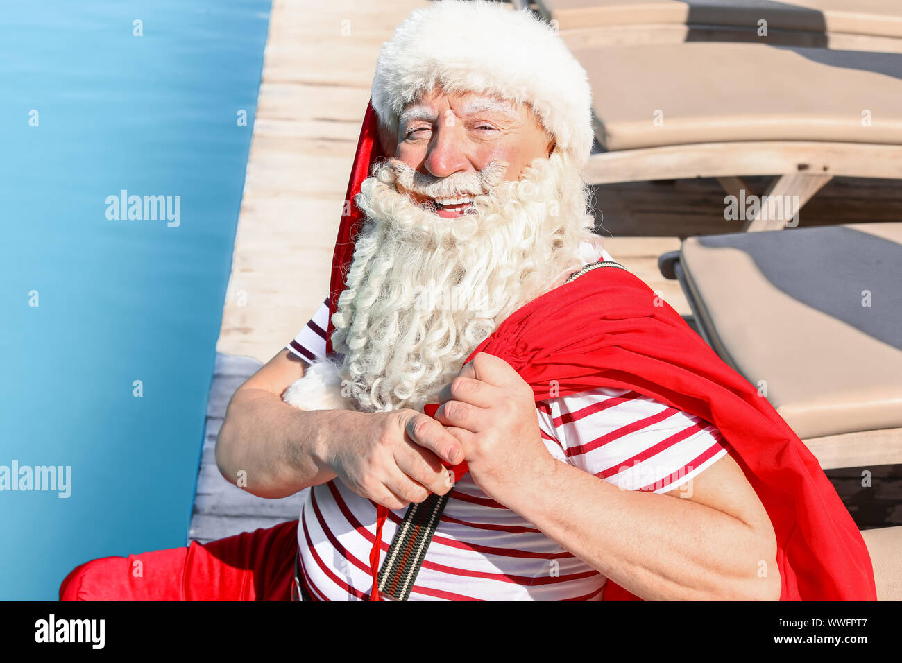 Santa Claus sitting on the edge of swimming pool at resort Stock Photo ...