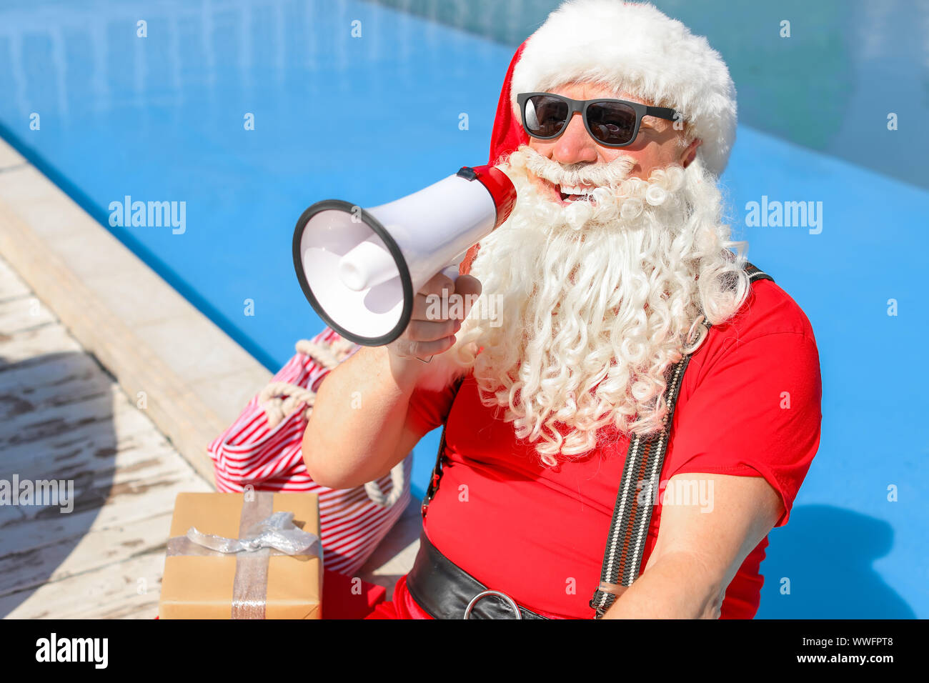 Cool Santa Claus with megaphone near swimming pool at resort Stock ...