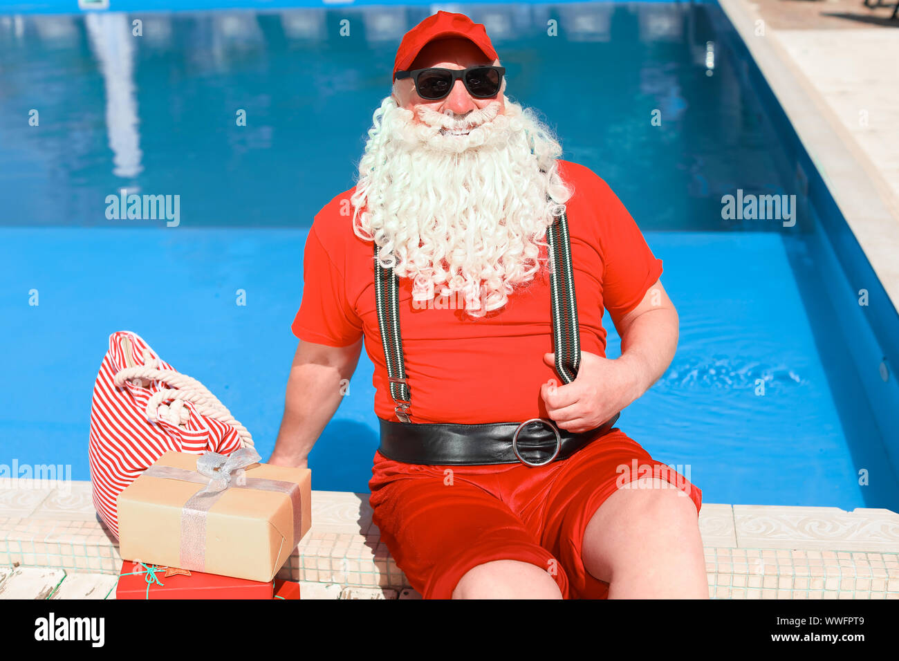Santa Claus with gifts near swimming pool at resort Stock Photo - Alamy