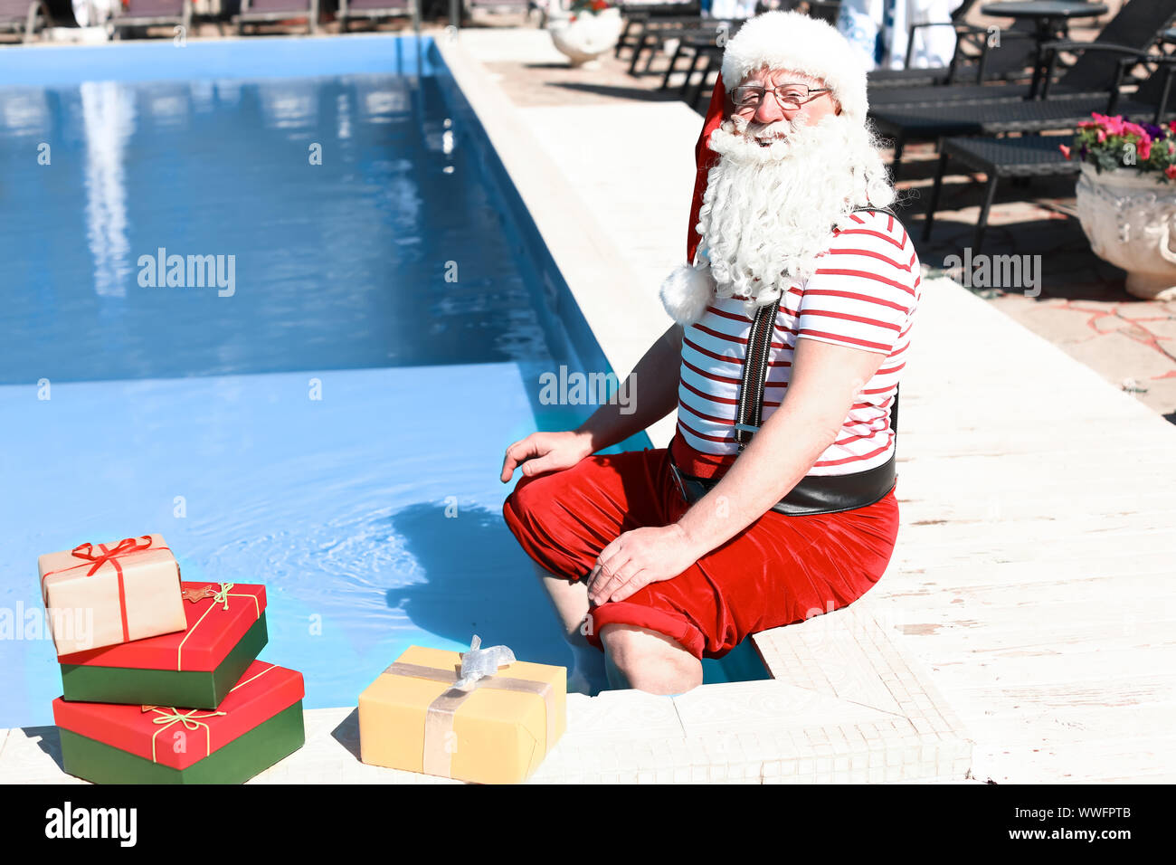 Santa Claus with gifts near swimming pool at resort Stock Photo - Alamy