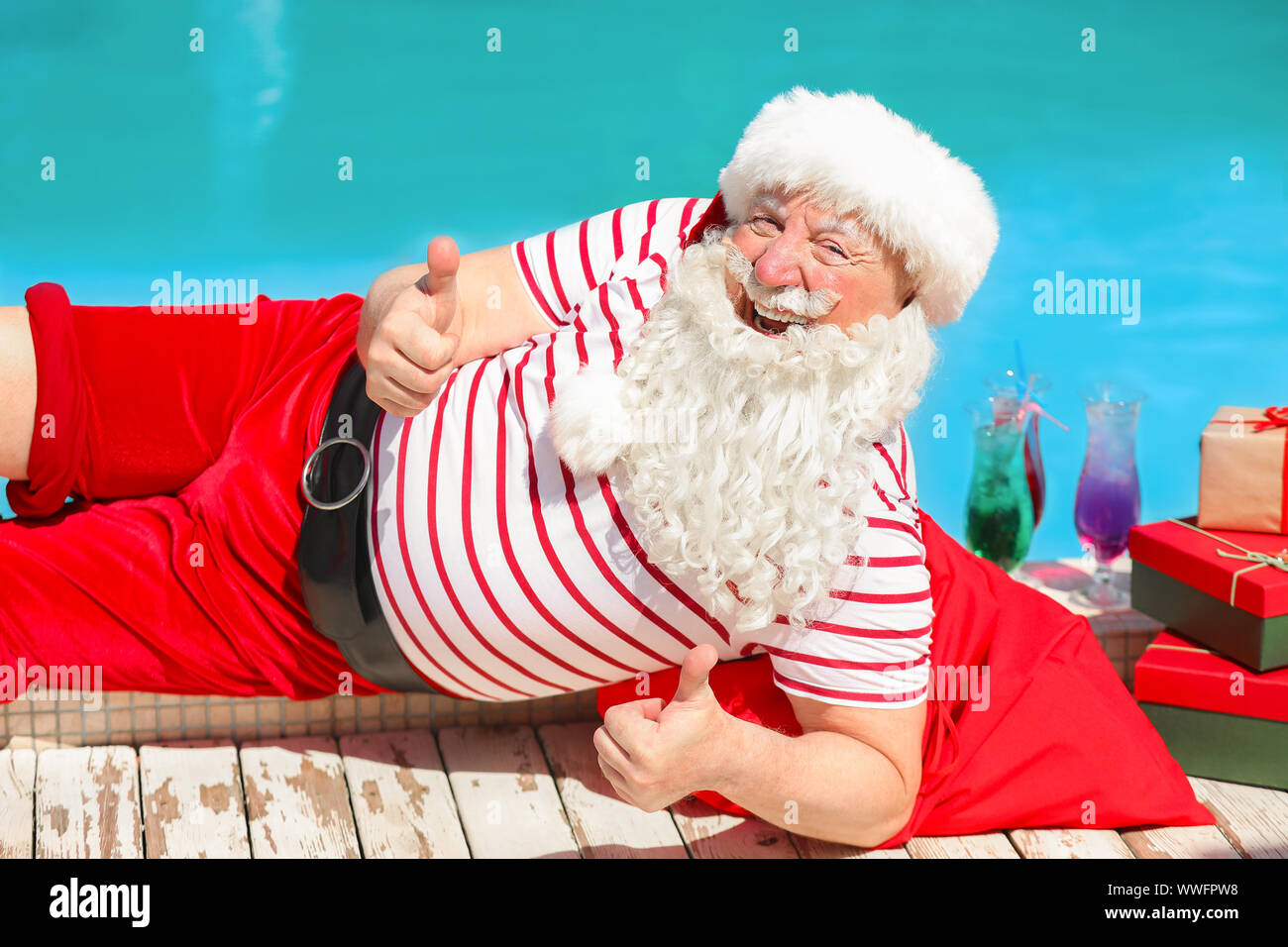 Santa Claus showing thumb-up near swimming pool at resort Stock Photo ...