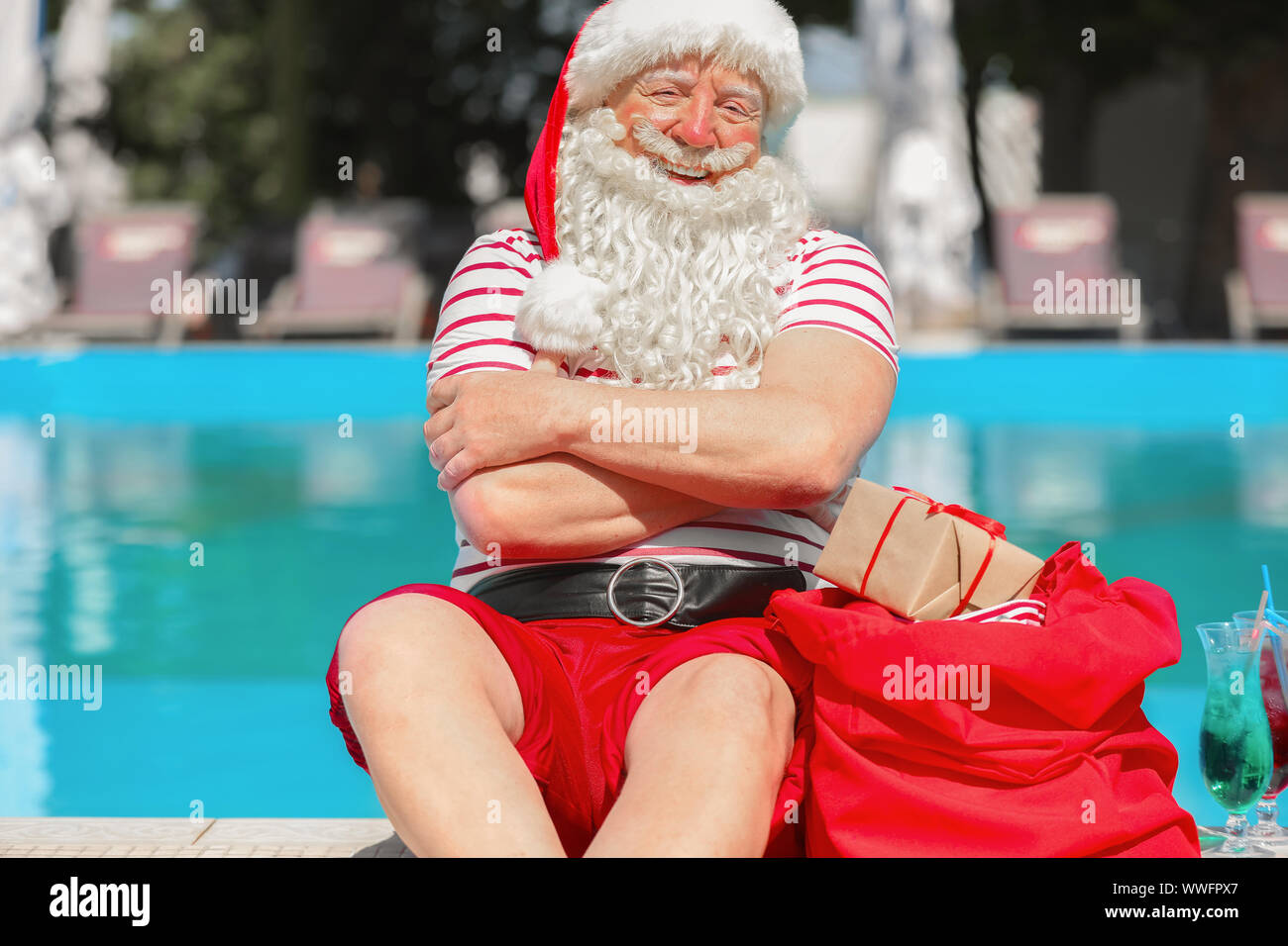 Santa Claus with gifts near swimming pool at resort Stock Photo - Alamy
