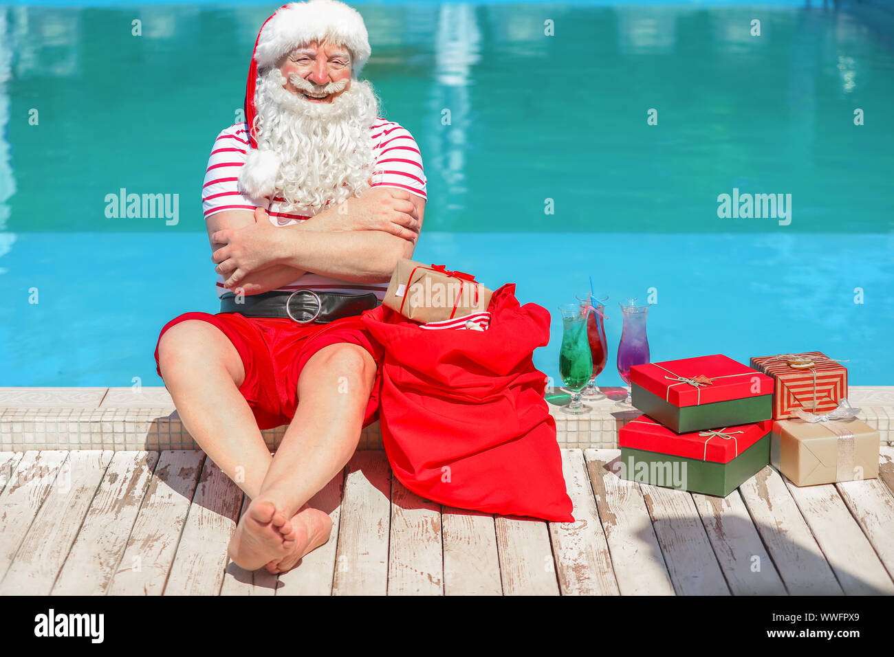 Santa Claus with gifts near swimming pool at resort Stock Photo - Alamy