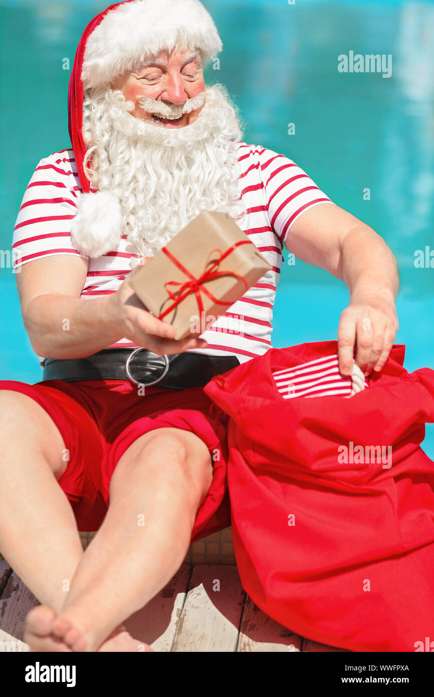 Santa Claus with gifts near swimming pool at resort Stock Photo - Alamy