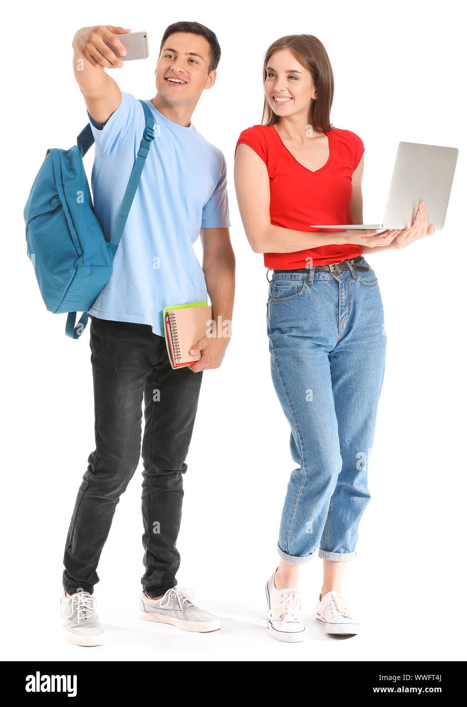 Portrait of young students with laptop taking selfie on white ...