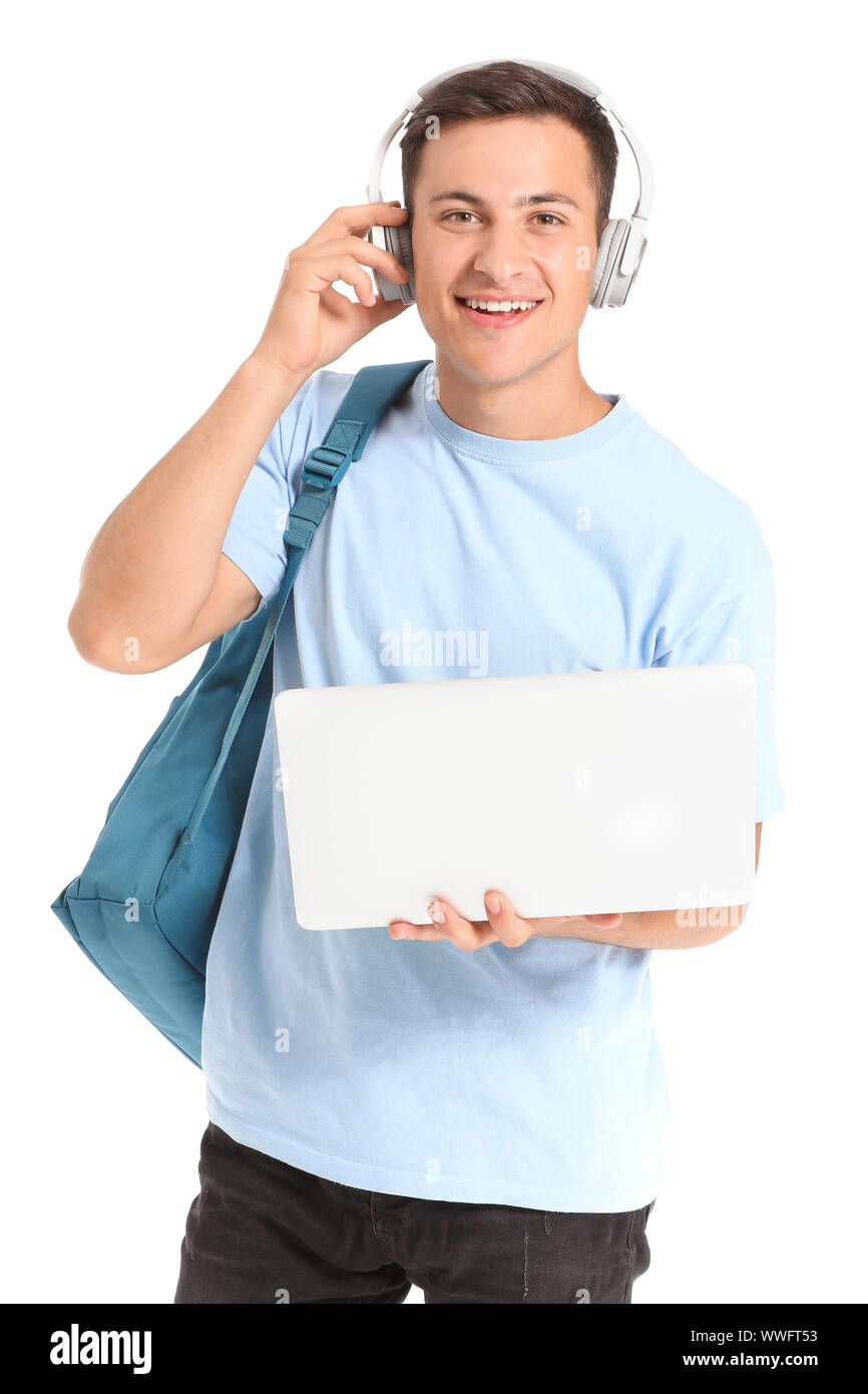 Portrait of young student with laptop and headphones on white ...