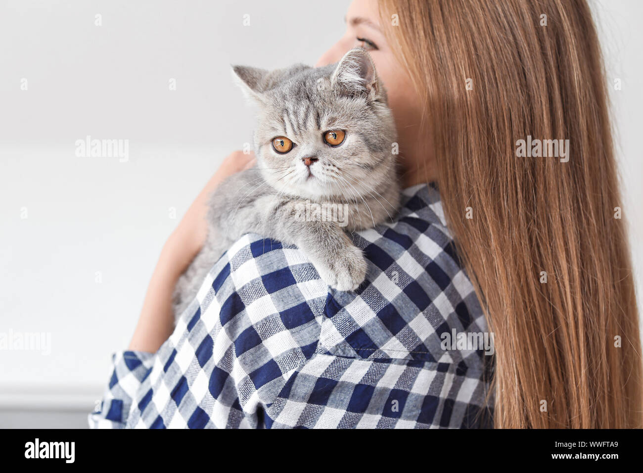 Beautiful young woman with cute cat at home Stock Photo - Alamy
