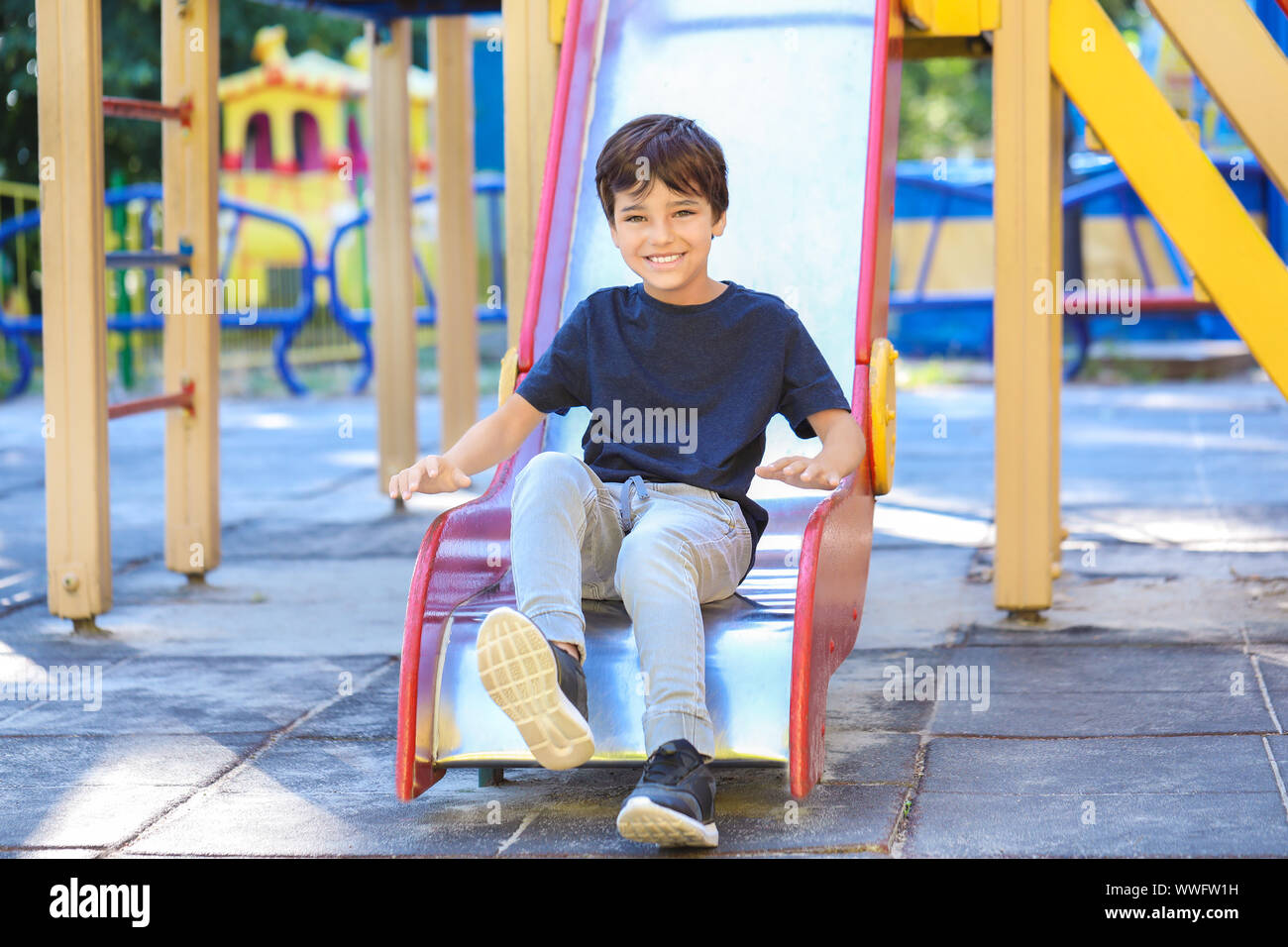 Cute little boy on slide in park Stock Photo - Alamy