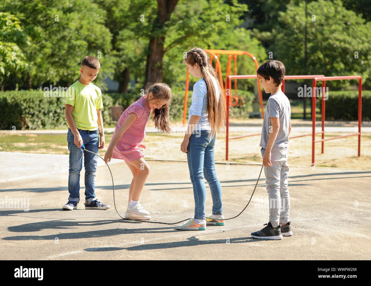 Cute little children jumping rope on playground Stock Photo - Alamy