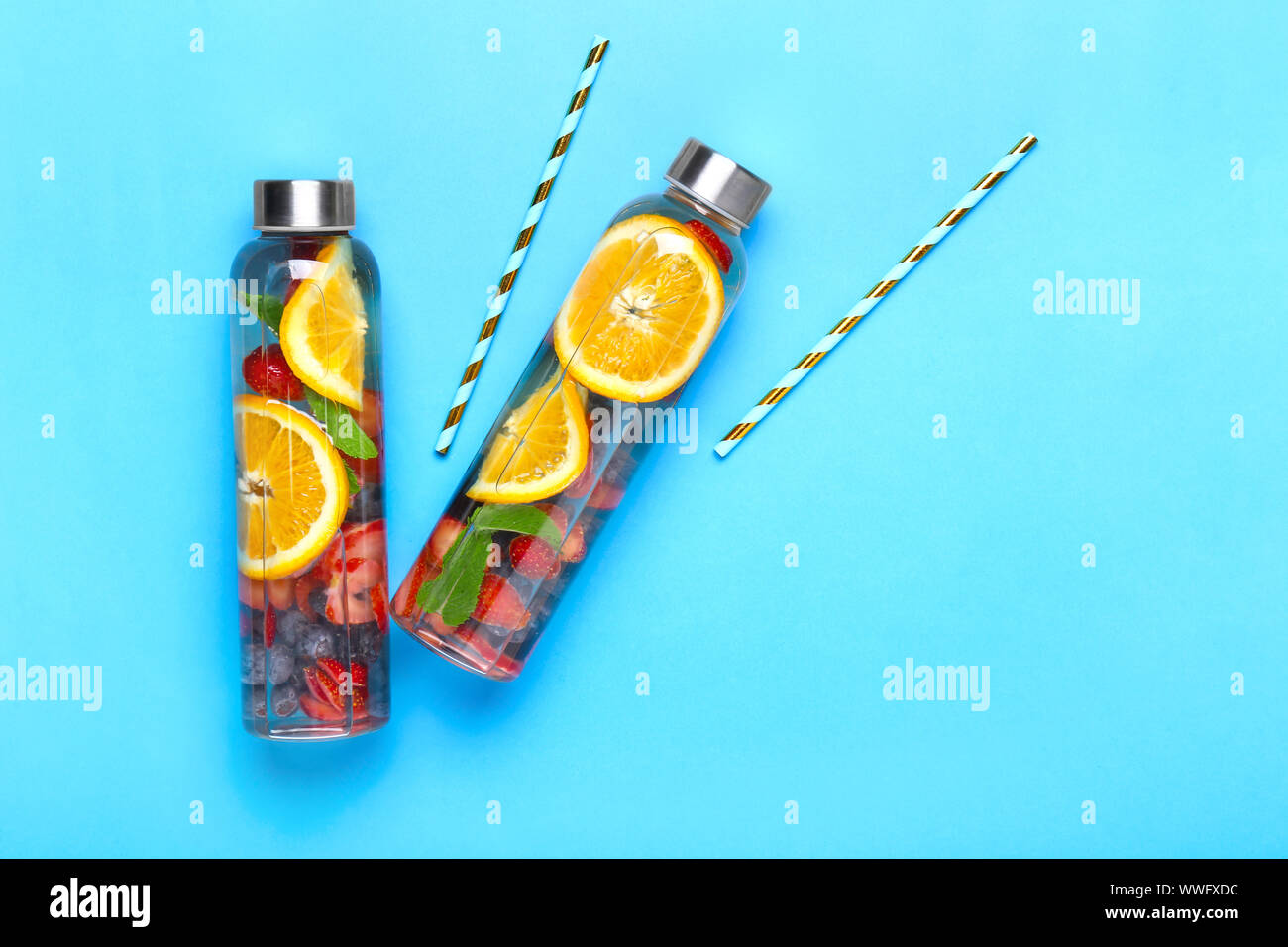 Bottles of tasty infused water on color background Stock Photo - Alamy