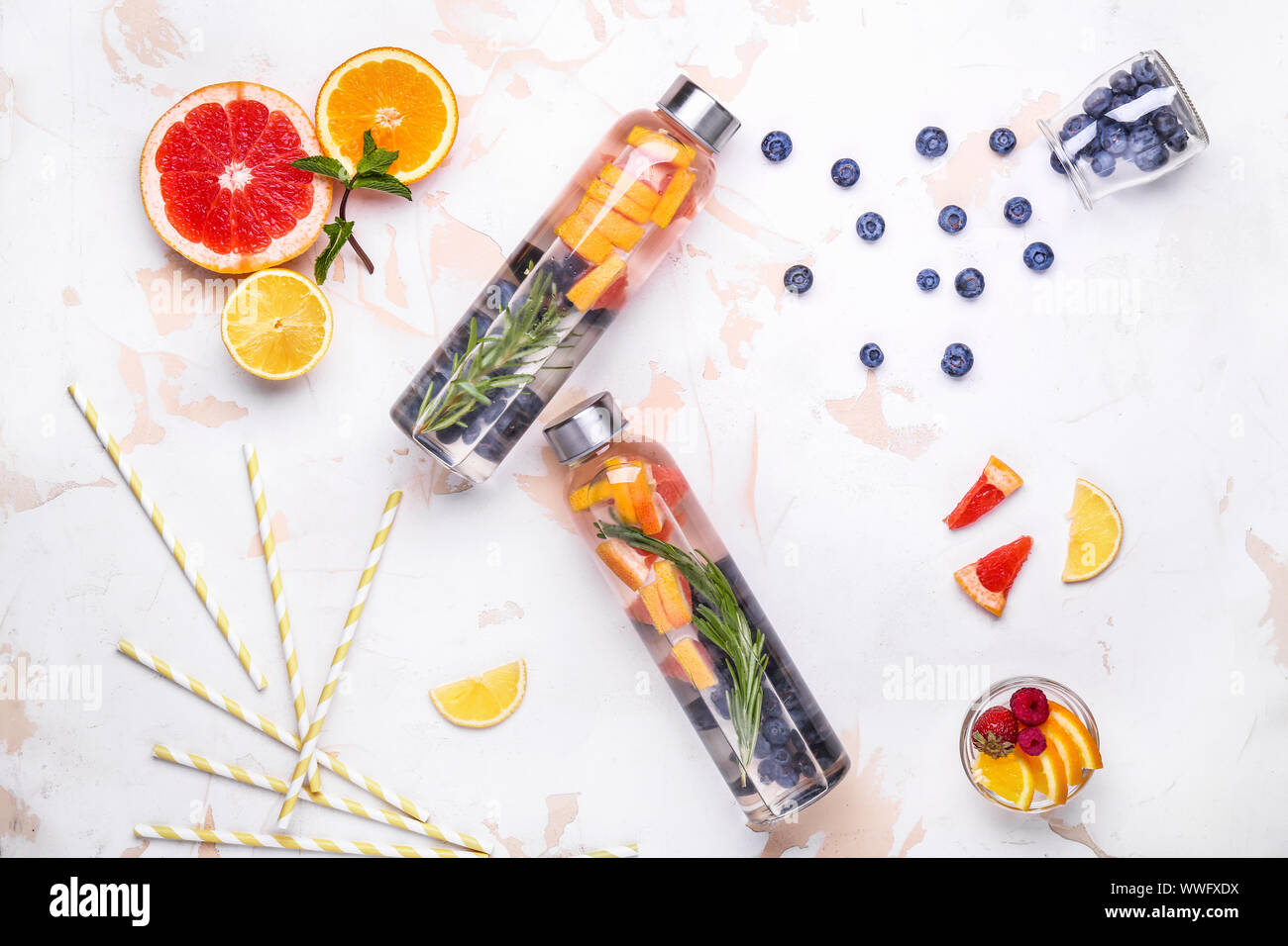 Bottles of tasty infused water on light background Stock Photo - Alamy