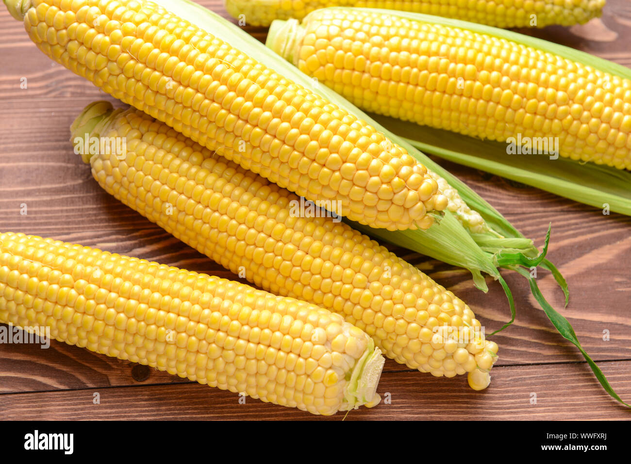 Fresh corn cobs on wooden background Stock Photo - Alamy