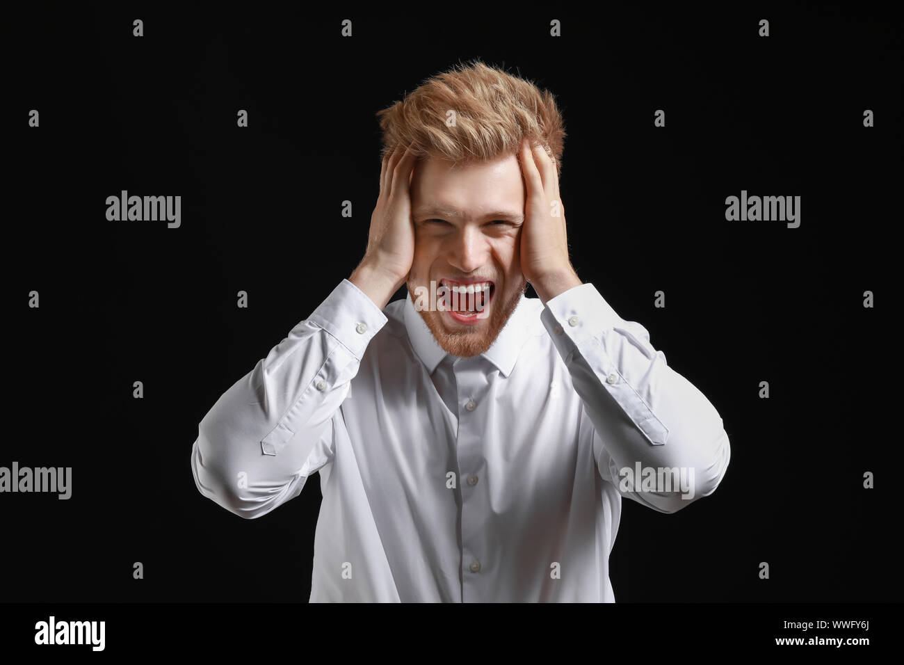 Stressed young man on dark background Stock Photo - Alamy