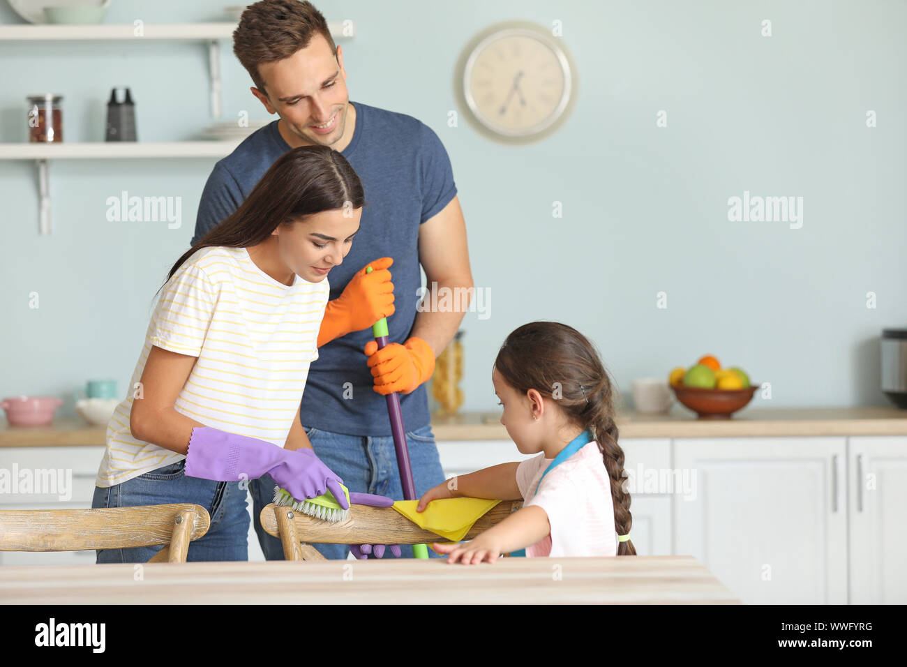 Happy family cleaning kitchen together Stock Photo - Alamy