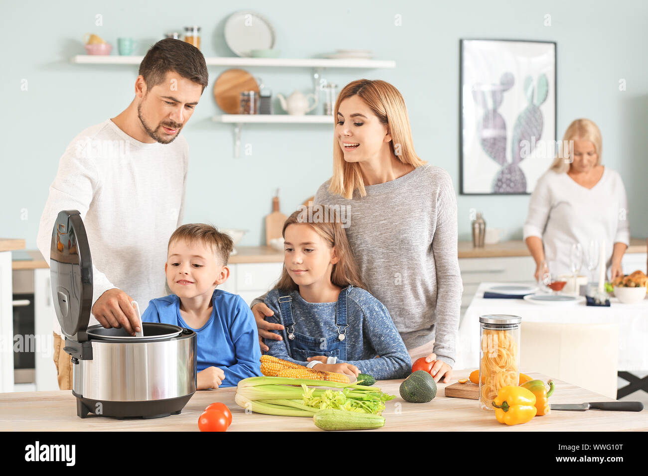Happy family using modern multi cooker in kitchen Stock Photo - Alamy