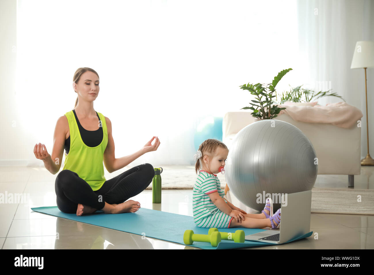 Sporty mother with little daughter training at home Stock Photo - Alamy