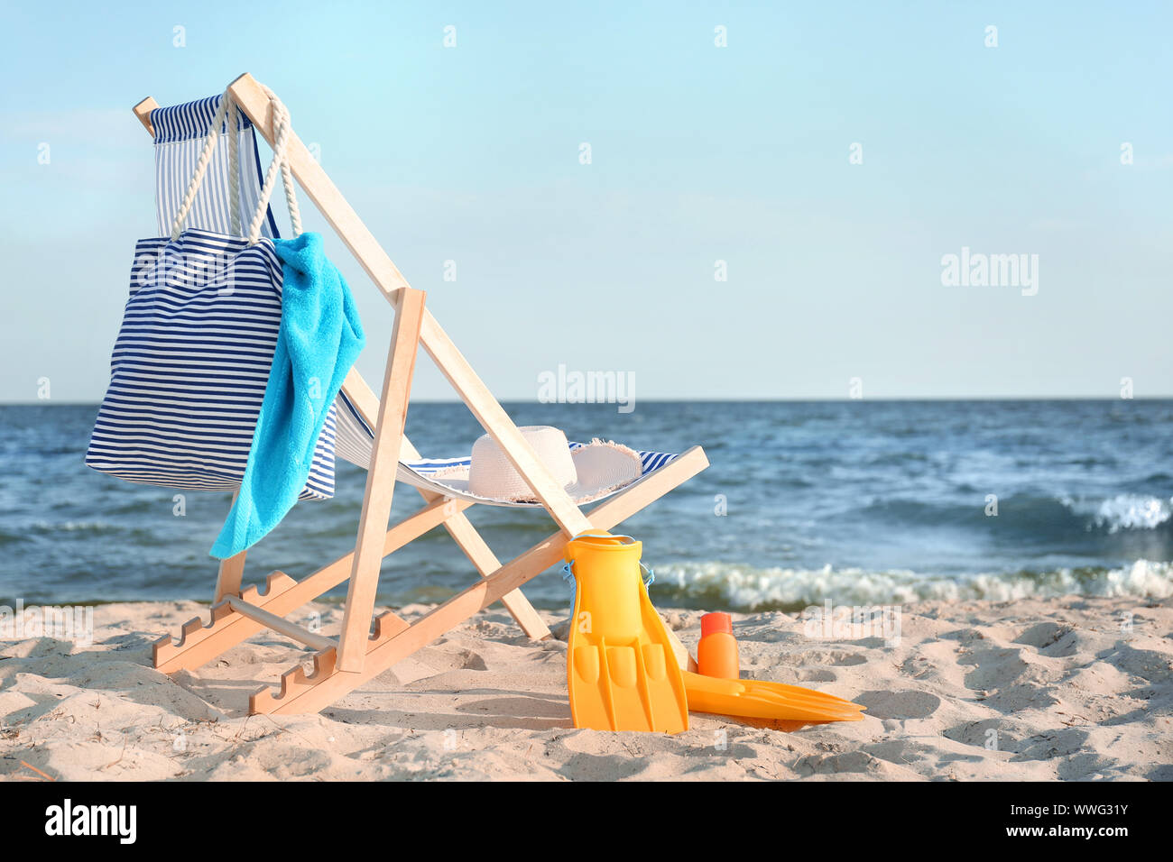 Chair with flippers, bag and accessories on sand beach Stock Photo - Alamy