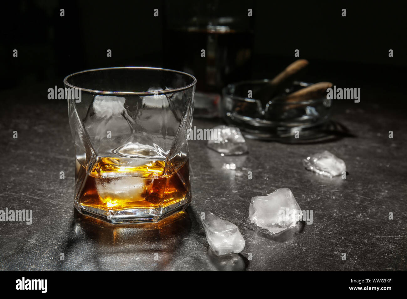 Glass of cold whiskey with ice on dark table Stock Photo - Alamy